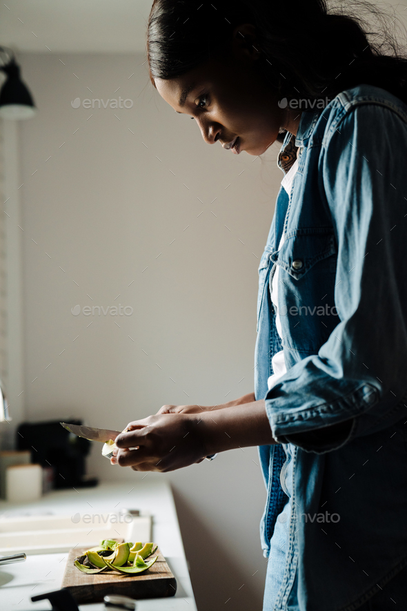 Black young woman wearing denim clothes cooking in kitchen Stock Photo ...