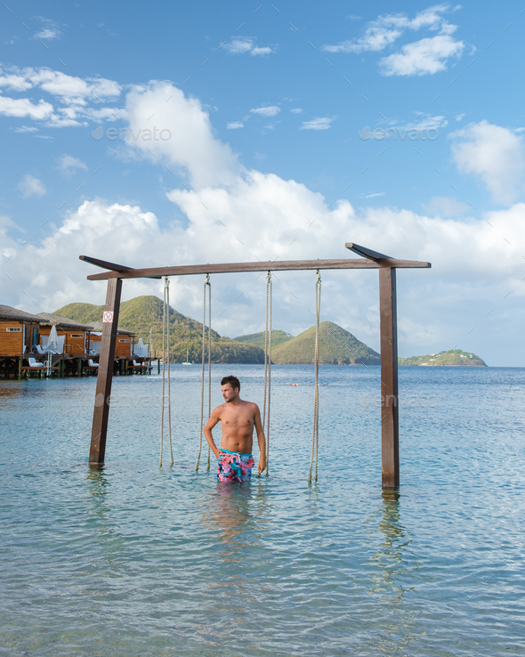 Men in a swing on the beach of the tropical Island Saint Lucia or St ...