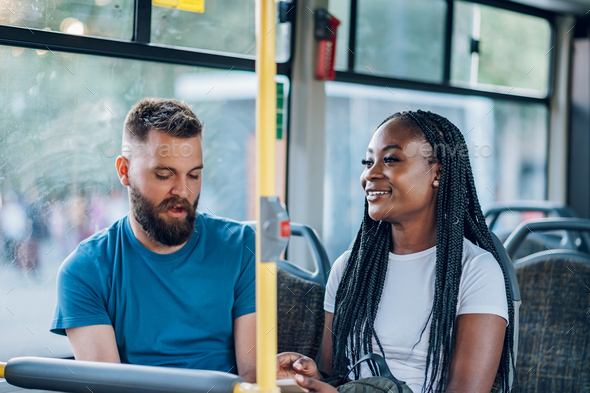 Multiracial friends talking while riding a bus in the city Stock Photo ...