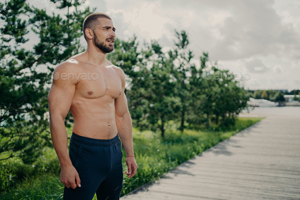 sporty man bodybuilder has workout outdoor, looks thoughtfully into ...