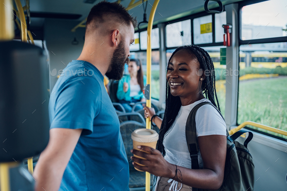 Multiracial friends talking while riding a bus in the city Stock Photo ...