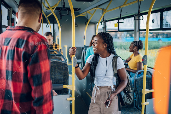 Multiracial friends talking while riding a bus in the city Stock Photo ...