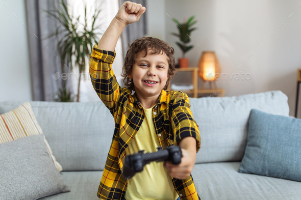 Online win. Happy little boy gamer with joystick celebrating victory in ...