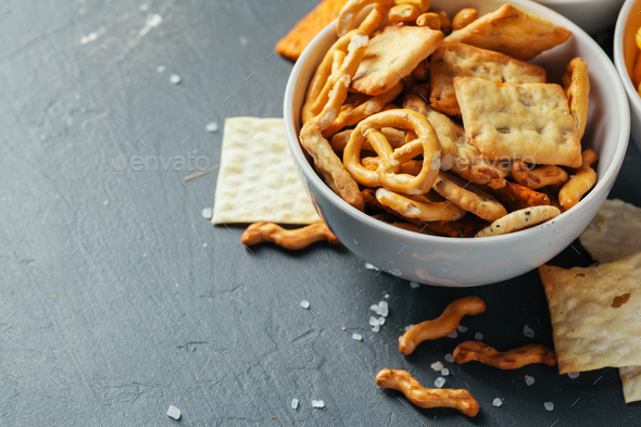Beer snacks on stone table. Various crackers, potato chips. Top view ...