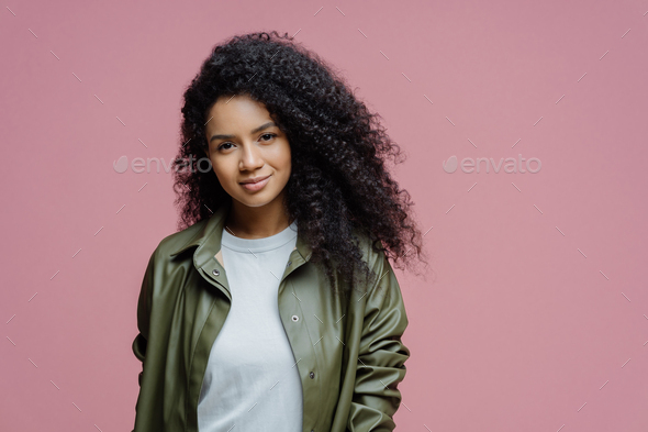 Isolated shot of serious dark skinned woman looks with confident calm ...