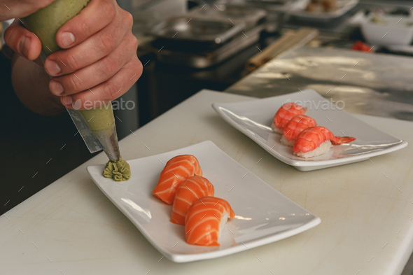 Close up of sushi master prepares sushi for serving in modern ...