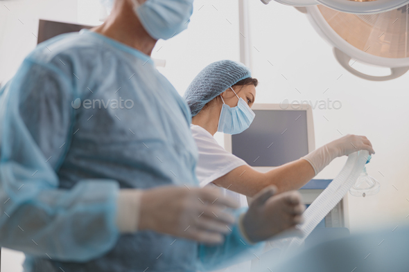 Nurse holding breathing mask for anesthesia standing in operation room ...