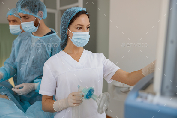 Nurse holding breathing mask in operating room before operation with ...