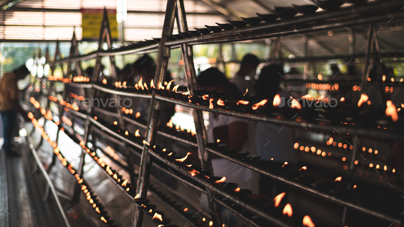 Oil clay pots holder racks in a Buddhist temple. Stock Photo by nsamenvato