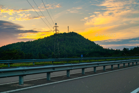 Expressway beautiful roadside scenery, rising sun behind the mountains ...