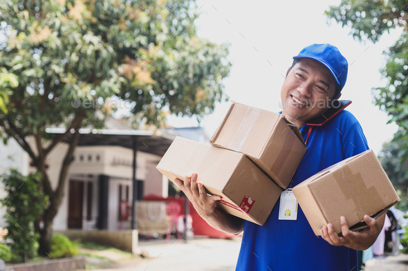 Busy delivery man calling the customer and bring box package on hands ...
