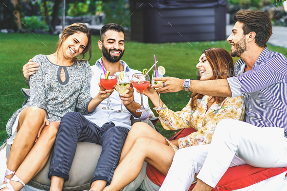 People toasting with fancy cocktails sitting on the couch Stock Photo ...