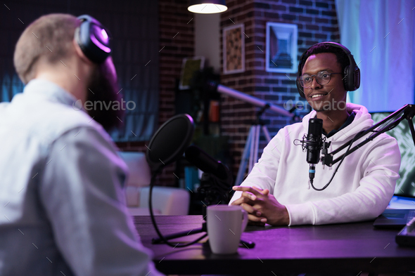 Podcast presenter having live conversation with young man Stock Photo ...