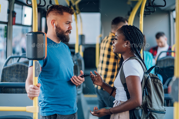 Multiracial friends talking while riding a bus in the city Stock Photo ...