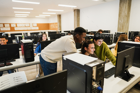 Young multiracial students using computers during business class at ...