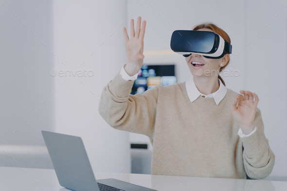 Young european girl in VR headset is gesturing concentrated on her ...