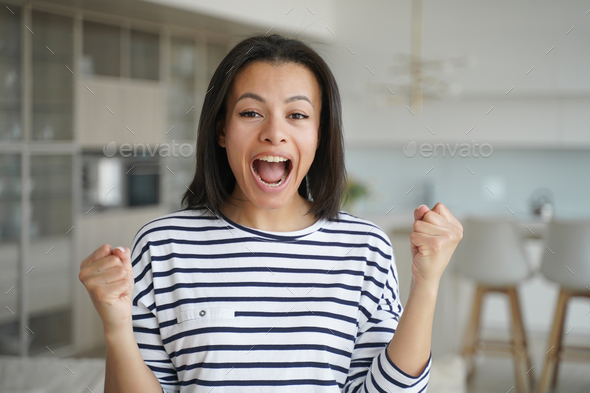 Excited happy woman makes yes gesture, celebrates relocation at new ...