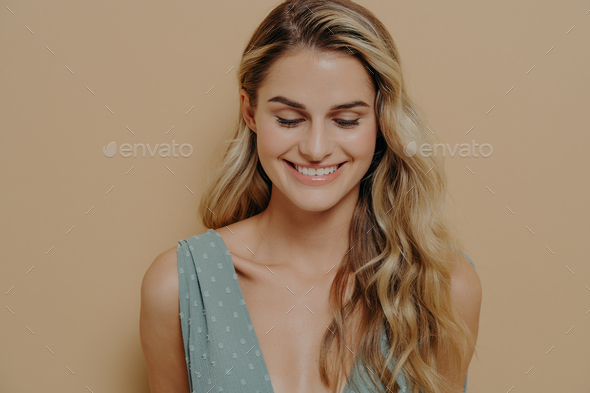 Shy timid young pretty blonde woman looking down with smile Stock Photo ...