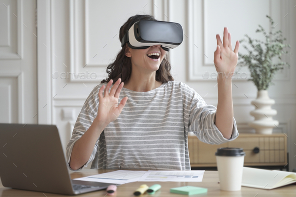 Excited amazed woman wearing VR glasses enjoying amazing virtual ...