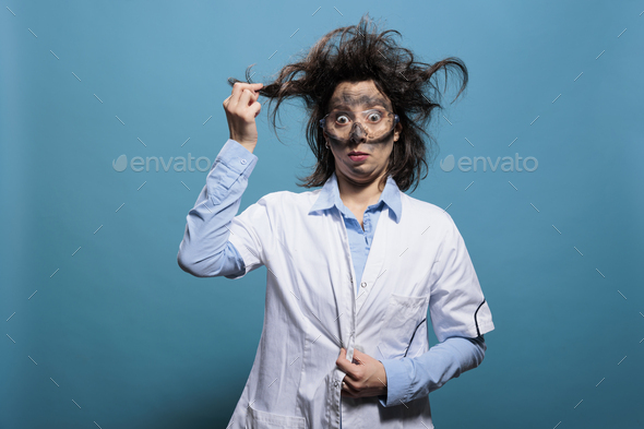 Wacky and crazy looking mad scientist grabbing messy hair while having ...