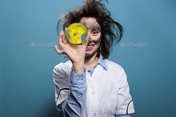 Crazy scientist with dirty face and messy hair with petri dish glass ...
