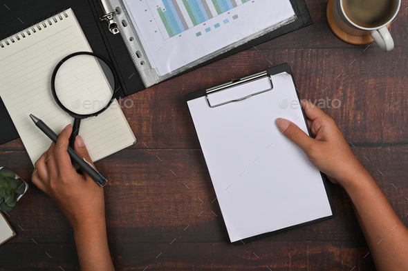 Above view female auditor examining the data on financial document ...