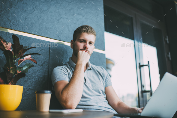 Calm man typing on modern laptop during work Stock Photo by GaudiLab