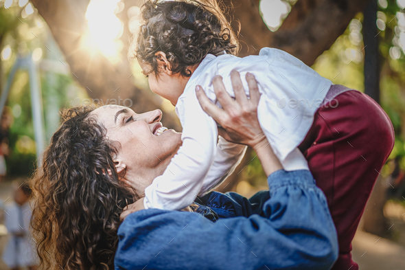 Mother raising her daughter in the park Stock Photo by baffos | PhotoDune