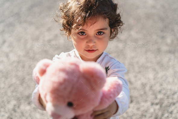 Little girl giving a Teddi bear Stock Photo by baffos | PhotoDune