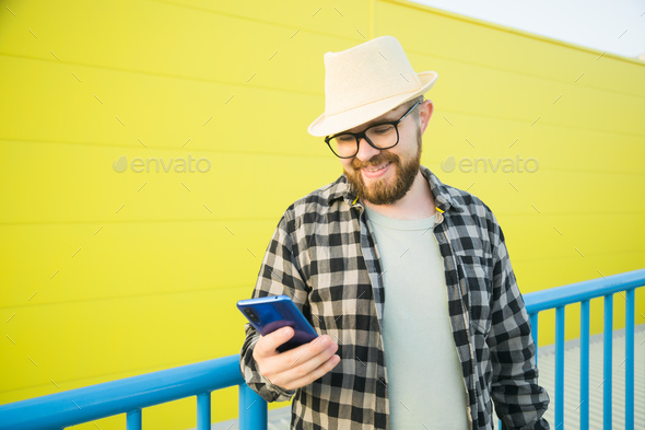 Portrait of attractive cheerful guy using smartphone for scrolling on ...