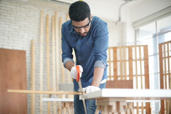 Carpenter or warehouse worker choosing raw wood material for the work ...