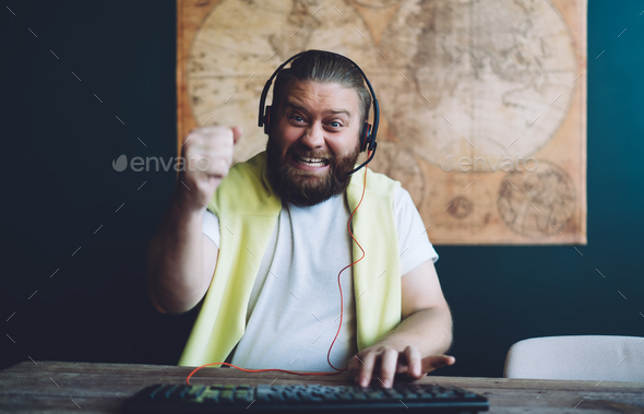 Furious guy clenching fist while playing computer game at table Stock ...