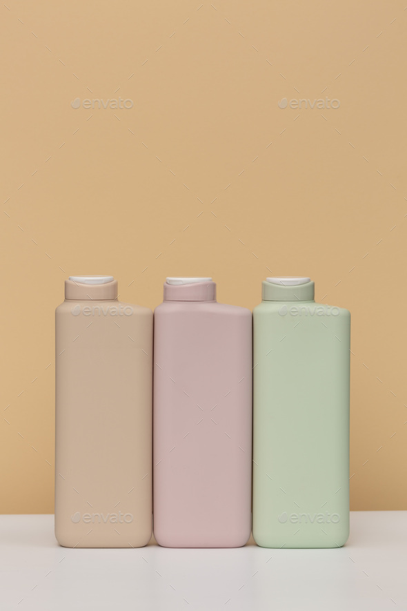 Three Bottles For Cosmetics Of Different Colours On A Beige Background ...