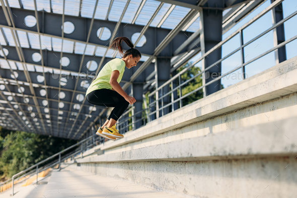 Strong woman doing high jump exercises on steps Stock Photo by tymoshchukph
