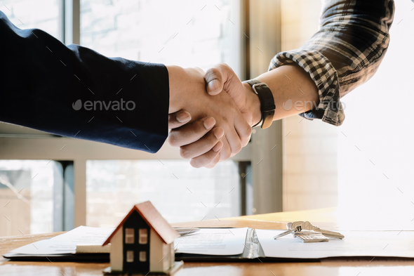Real estate agent and customers shaking hands together celebrating ...