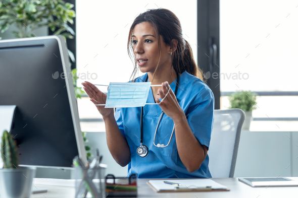 Female doctor explaining to her patient how to put on surgical mark ...