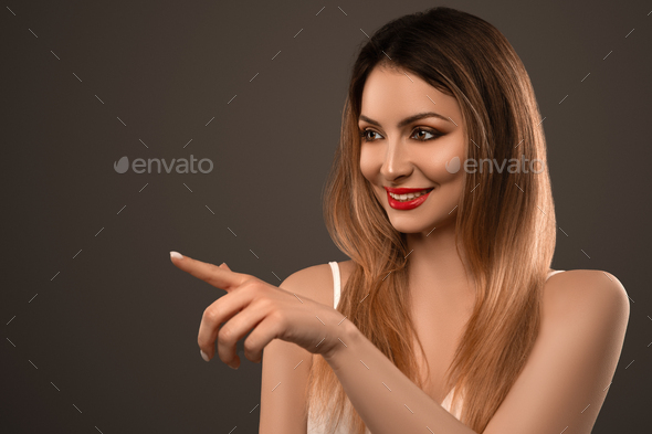 Beautiful Caucasian female model pointing your product. Copyspace Stock ...