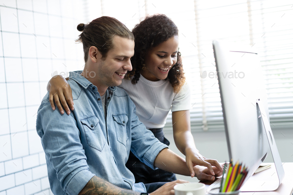 Creative young couple working on Desktop Computer from home office with ...