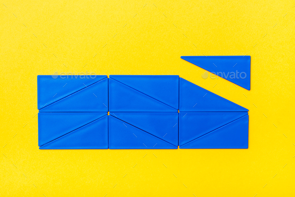 Blue plastic triangles are laid out in straight rows in a rectangle on ...