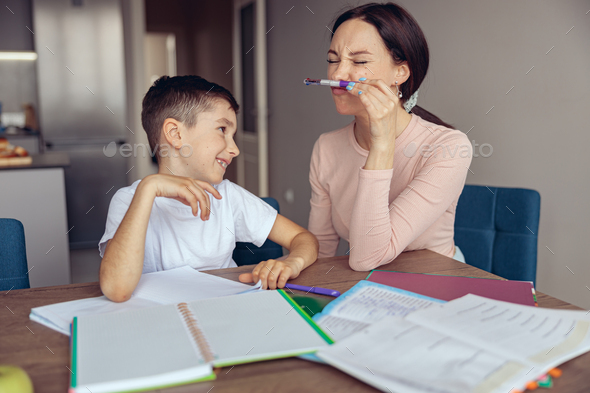 Pretty young mother having fun, making laugh her small son, mocking ...
