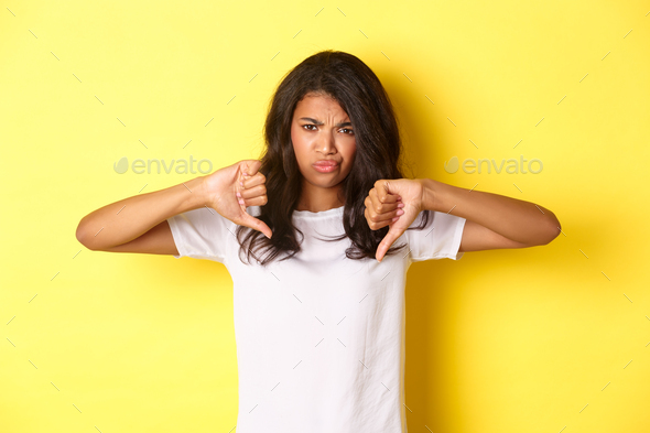 Image of skeptical, unamused cute african-american girl, showing thumbs ...