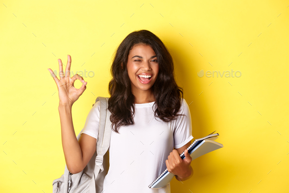 Portrait of confident african-american female student, showing okay ...