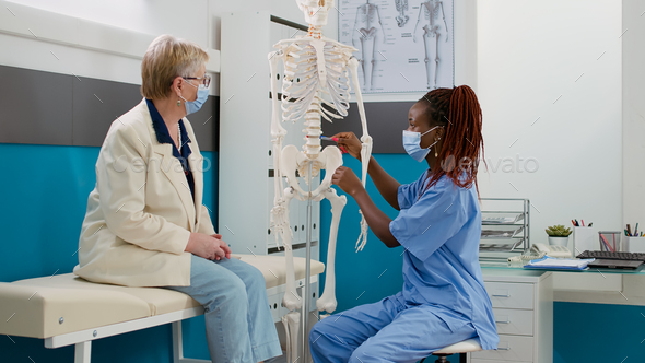 Osteopath nurse examining human skeleton bones with patient Stock Photo ...