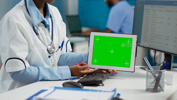 General practitioner showing horizontal greenscreen on tablet Stock ...