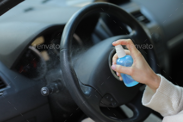 Hand of woman is spraying alcohol,disinfectant spray in car,safety ...