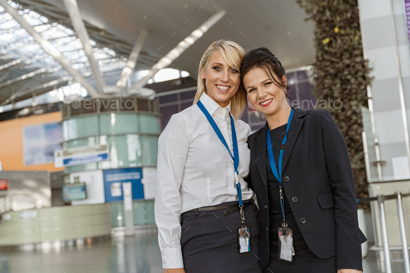 Portrait of smiling female airport employees at their workplace in ...