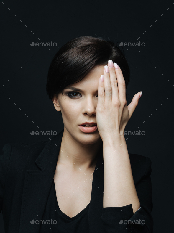 Stunning lady hiding half of face with hand Stock Photo by tymoshchukph