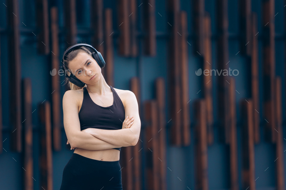 Woman standing with crossed arms, bending head. Stock Photo by tymoshchukph