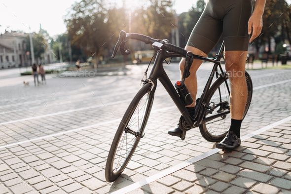Close up of cyclist with muscular legs sitting on bike Stock Photo by ...