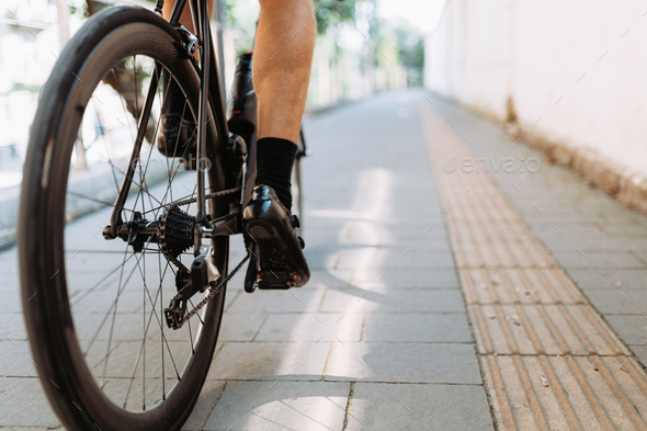 Close up of cyclist with muscular legs riding bike on street Stock ...